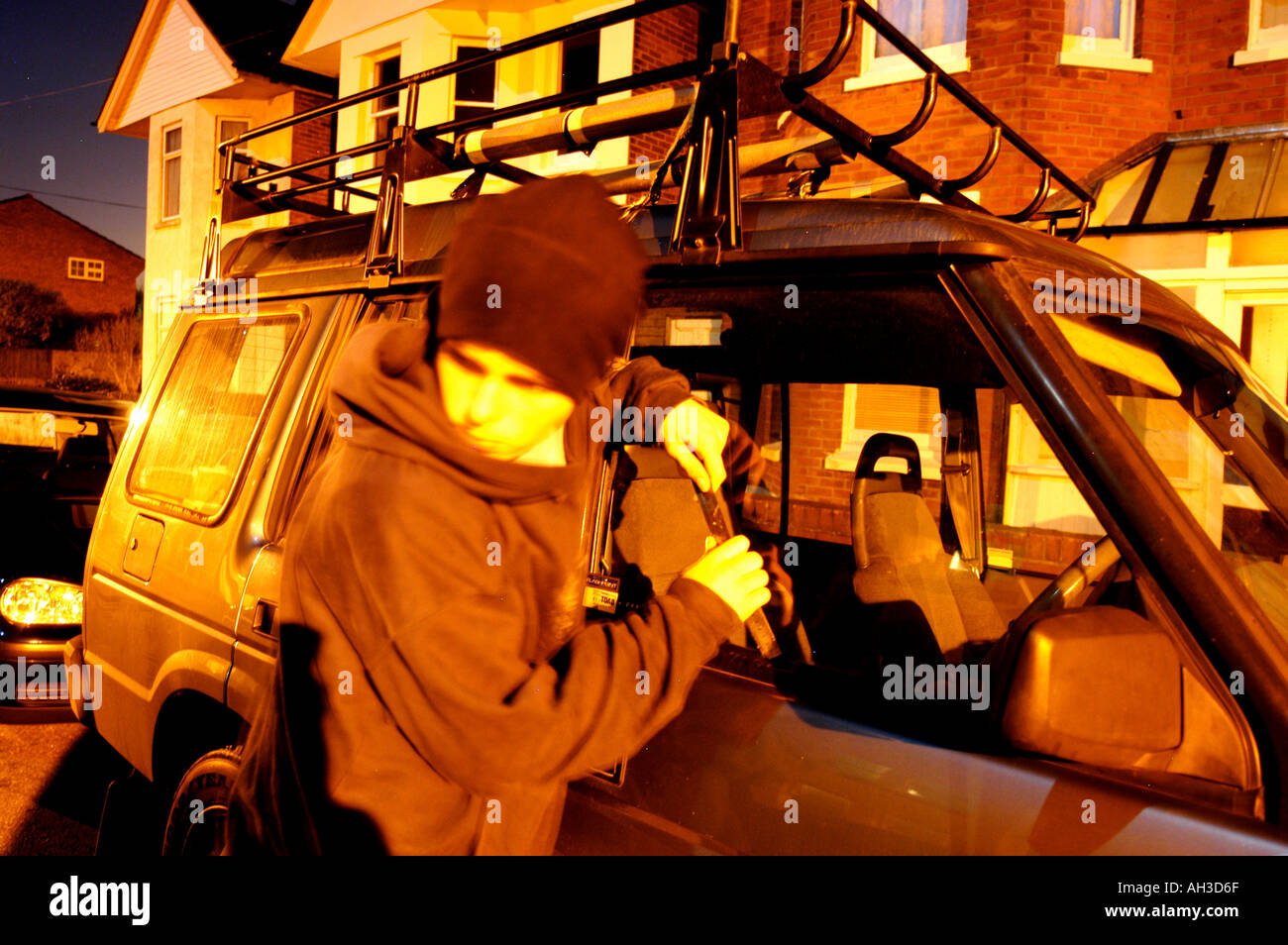 teenage car thief breaking in to a landrover discovery Stock Photo - Alamy