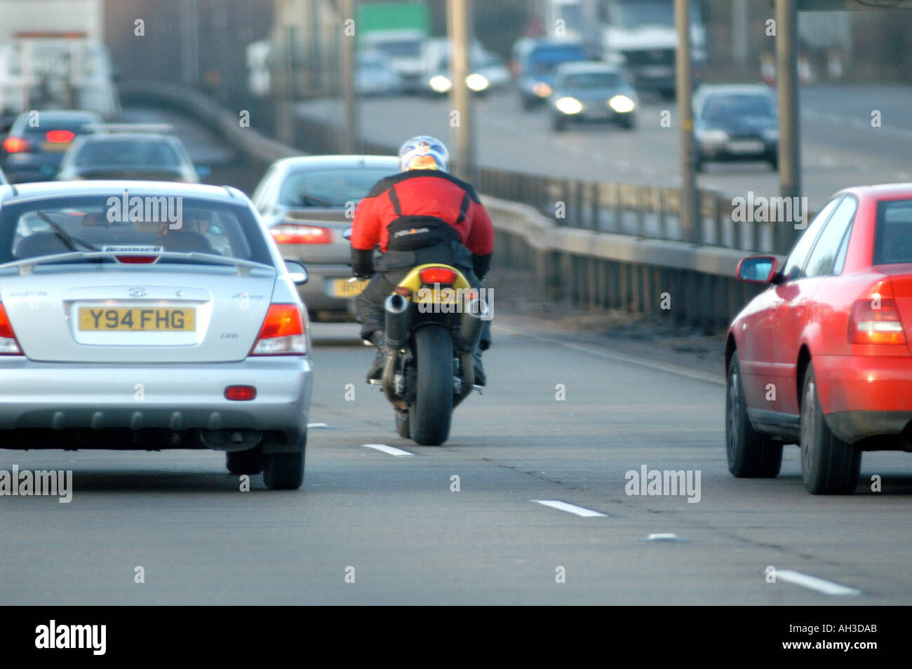 motorcycle cutting through traffic in london uk Stock Photo - Alamy