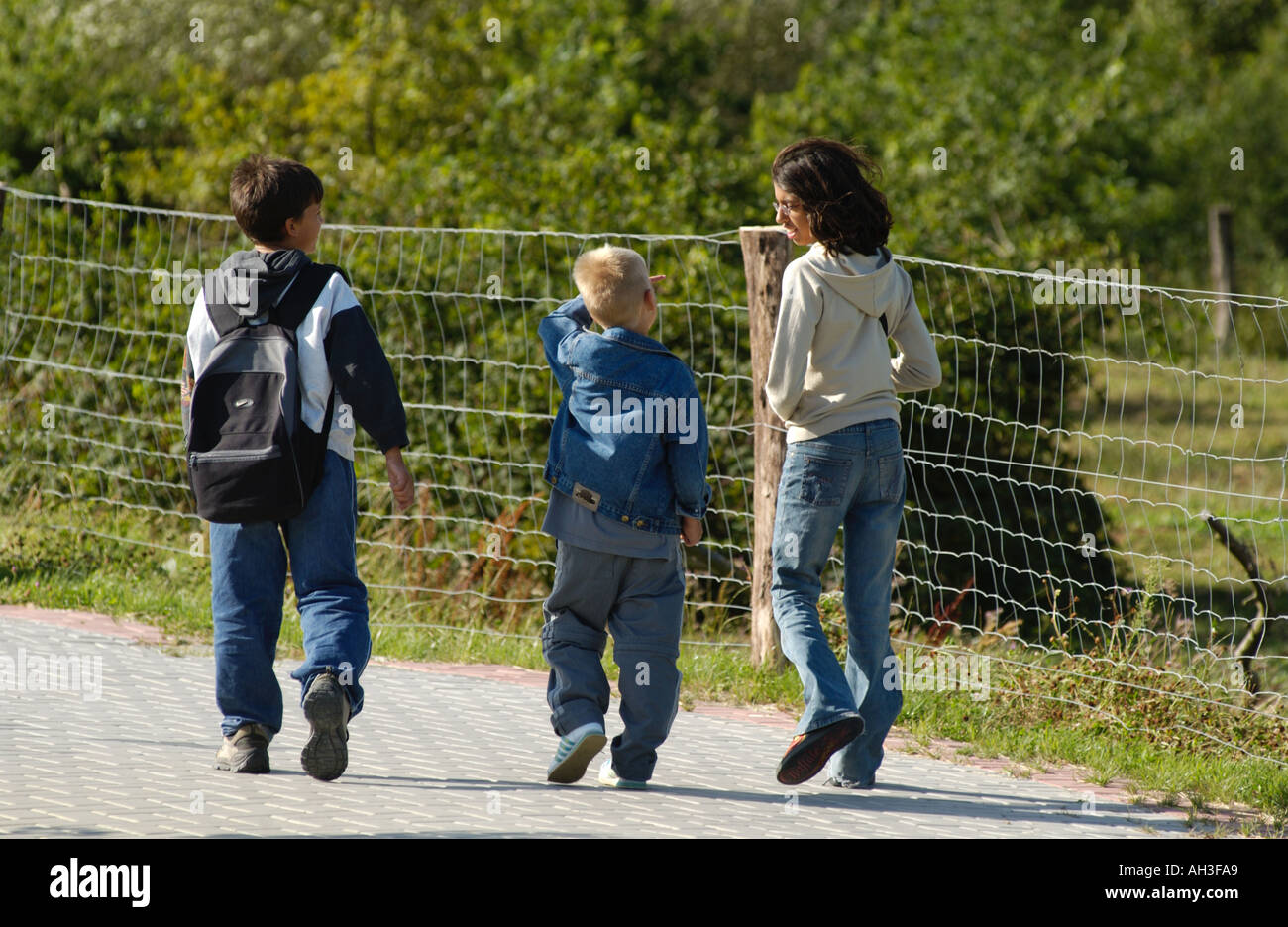 three kids walking Stock Photo - Alamy