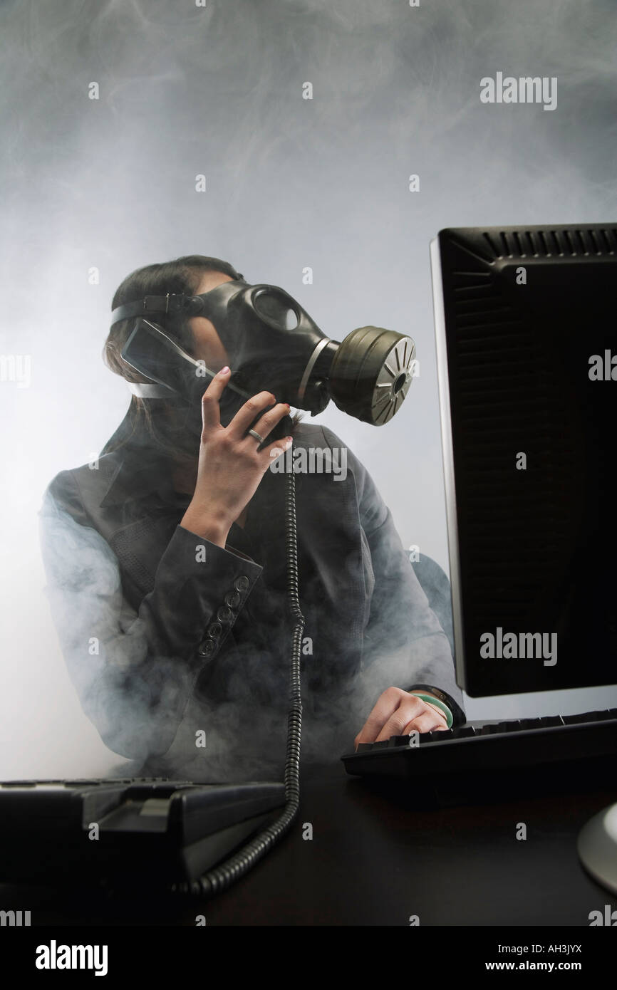 Businessperson wearing gas mask in smokey office Stock Photo - Alamy
