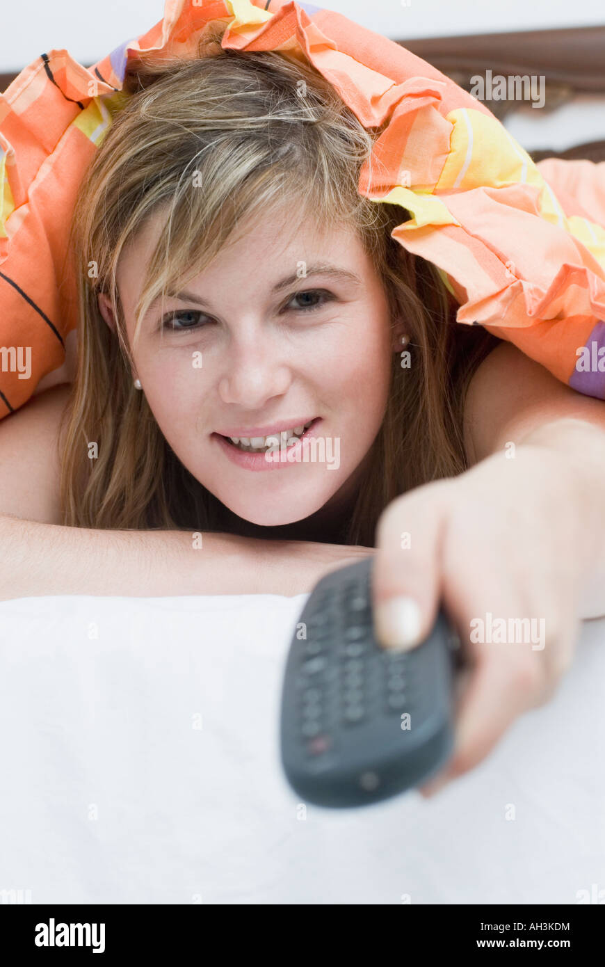 Portrait of a young woman using a remote control Stock Photo - Alamy