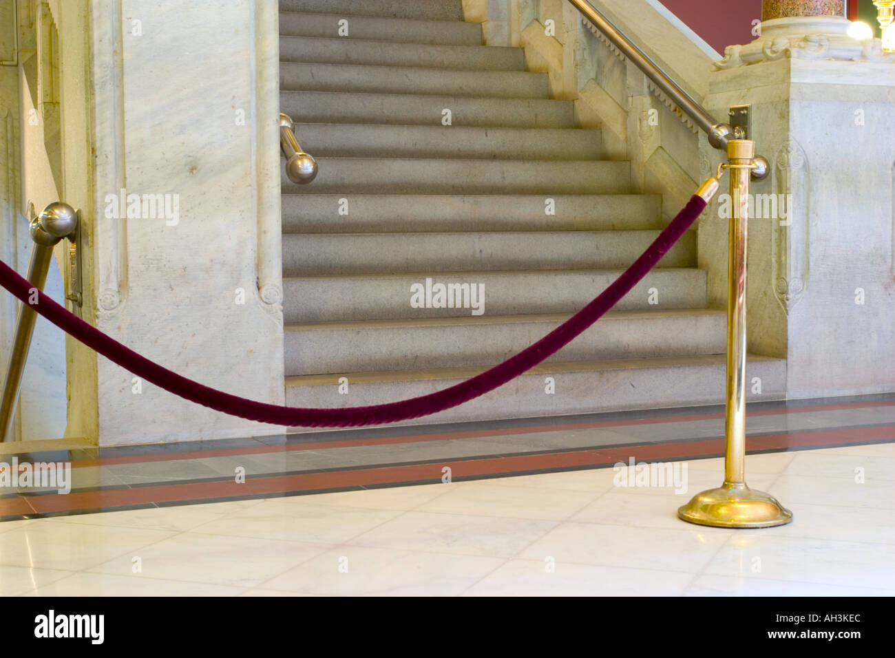 Thick red horizontal cord attached to two vertical poles in front of a ...