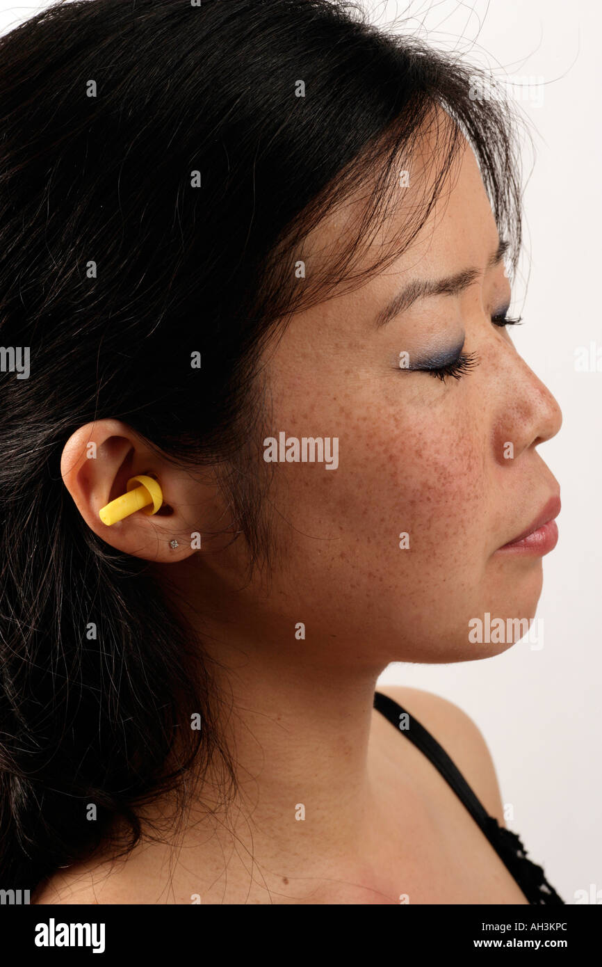 A young asian or japanese lady wearing ear defenders for protection or ...