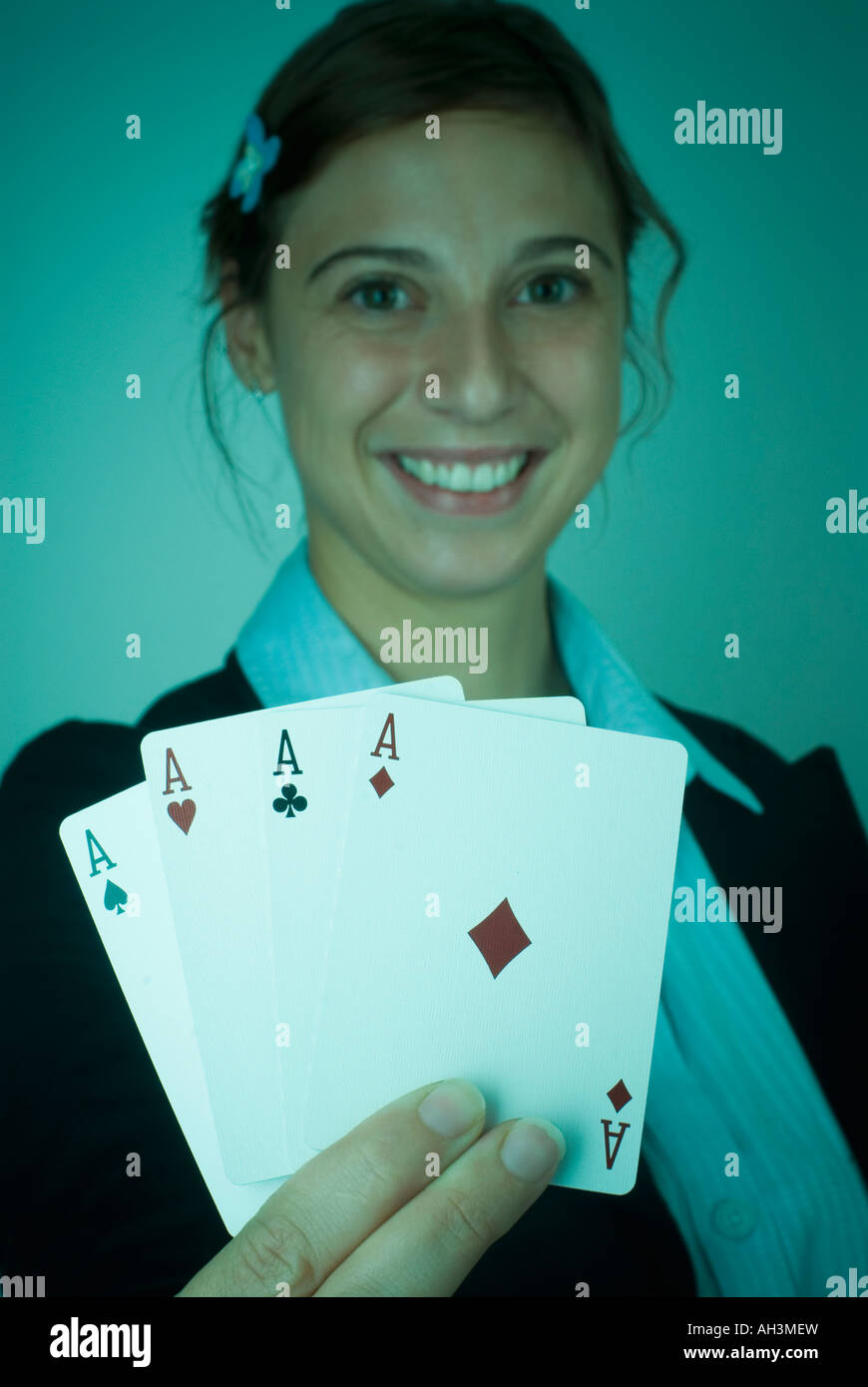 Portrait of a young woman holding playing cards and smiling Stock Photo ...