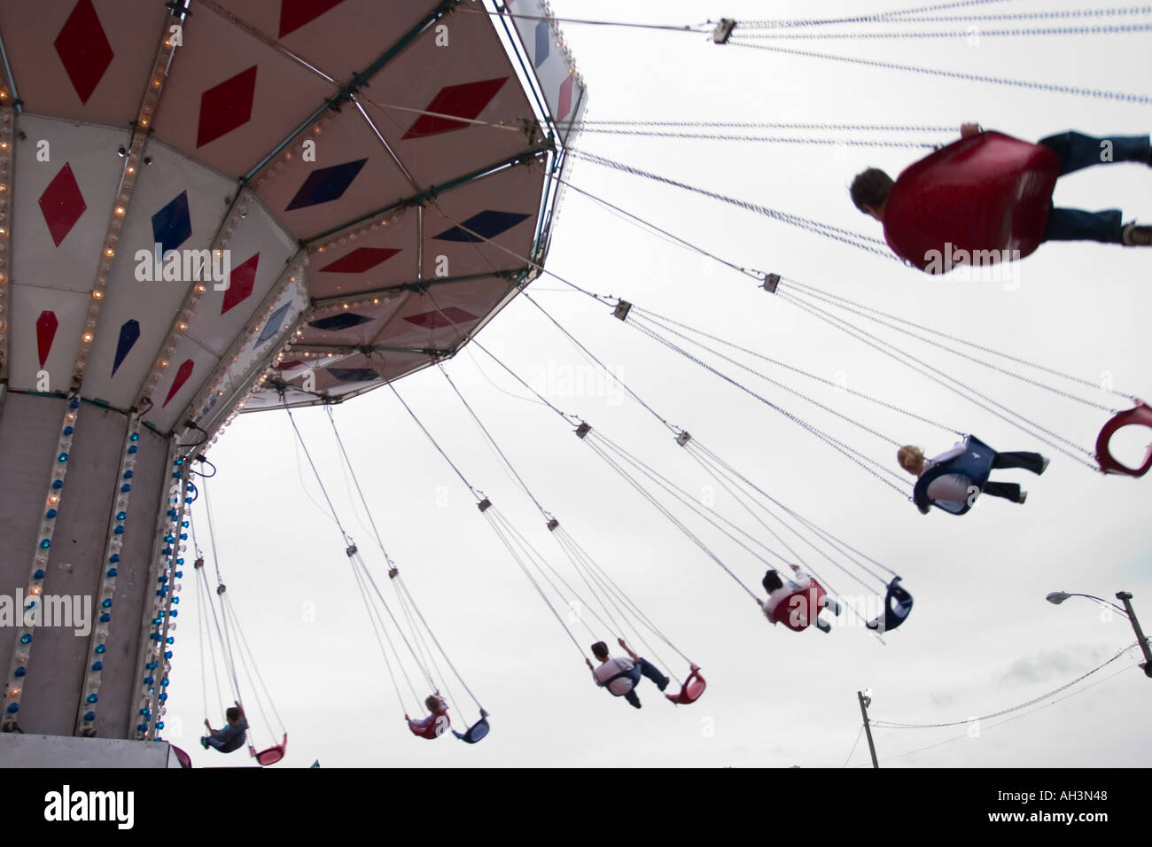 People at a carnival at a fair on a swing ride Stock Photo - Alamy