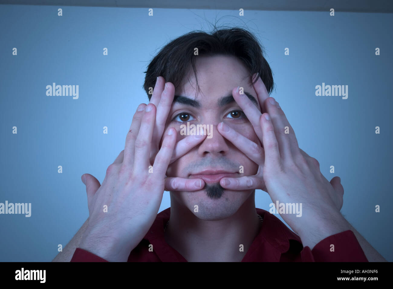 Woman's hands on the face of a young man Stock Photo - Alamy