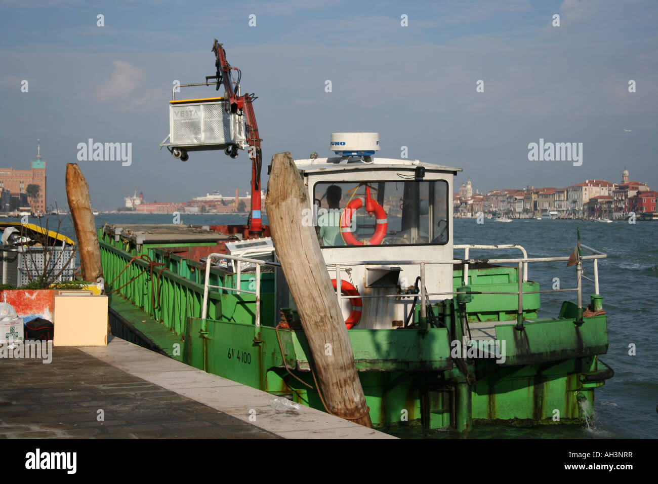 Venetian rubbish collection boat with crane emptying trash containers ...