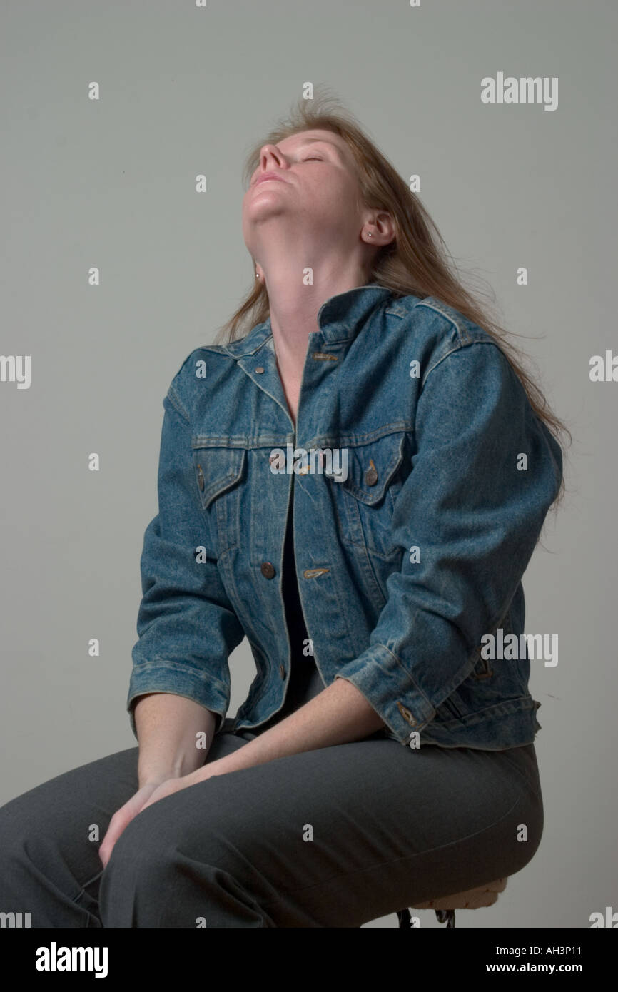 Woman in her mid thirties sitting with her head bent backwards Model ...
