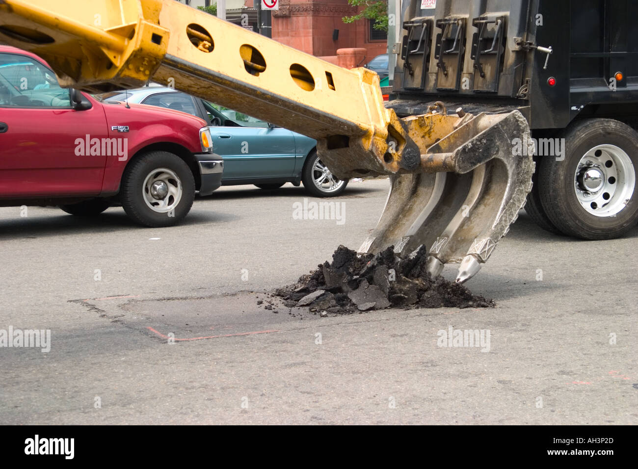 Large mechanical claw digging into a city street Stock Photo - Alamy