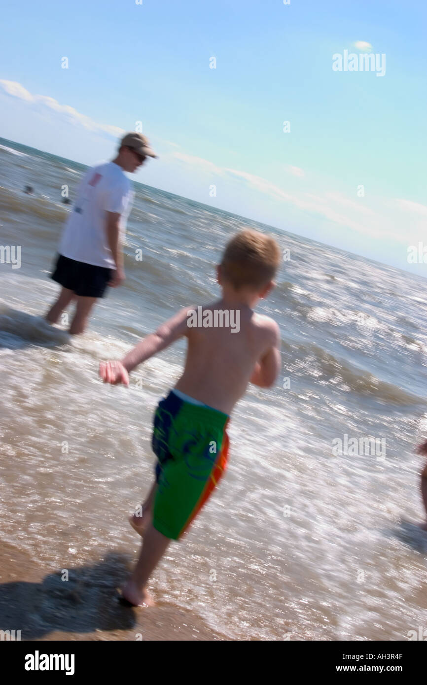 Young boy running in the water at the beach Stock Photo - Alamy