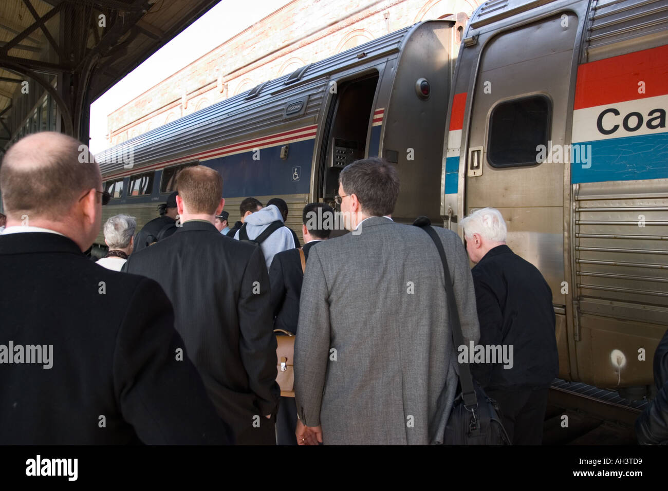 Commuters boarding a passenger train at a train station Stock Photo - Alamy