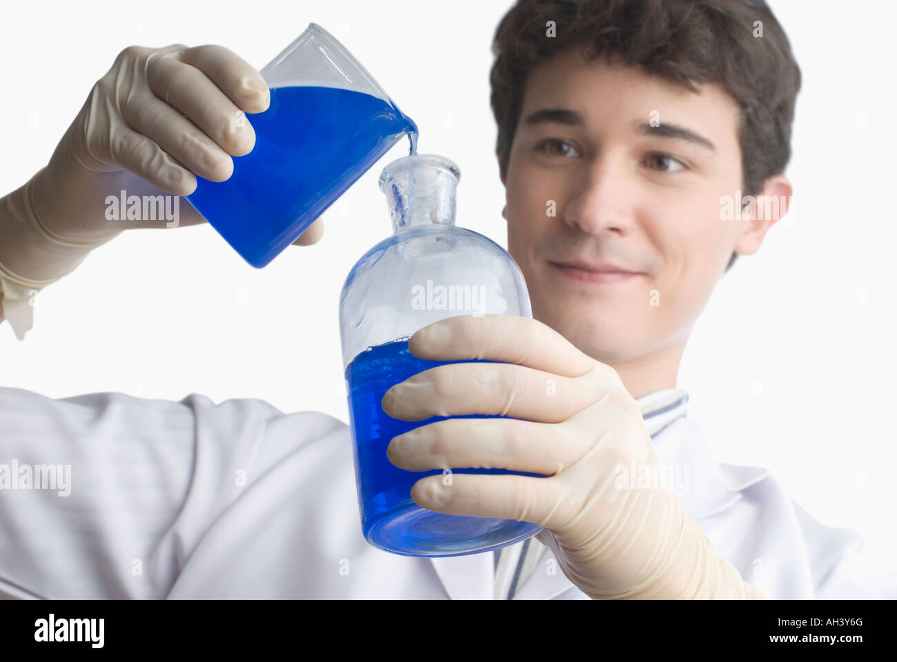 Close-up of a scientist pouring liquid into a flask Stock Photo - Alamy