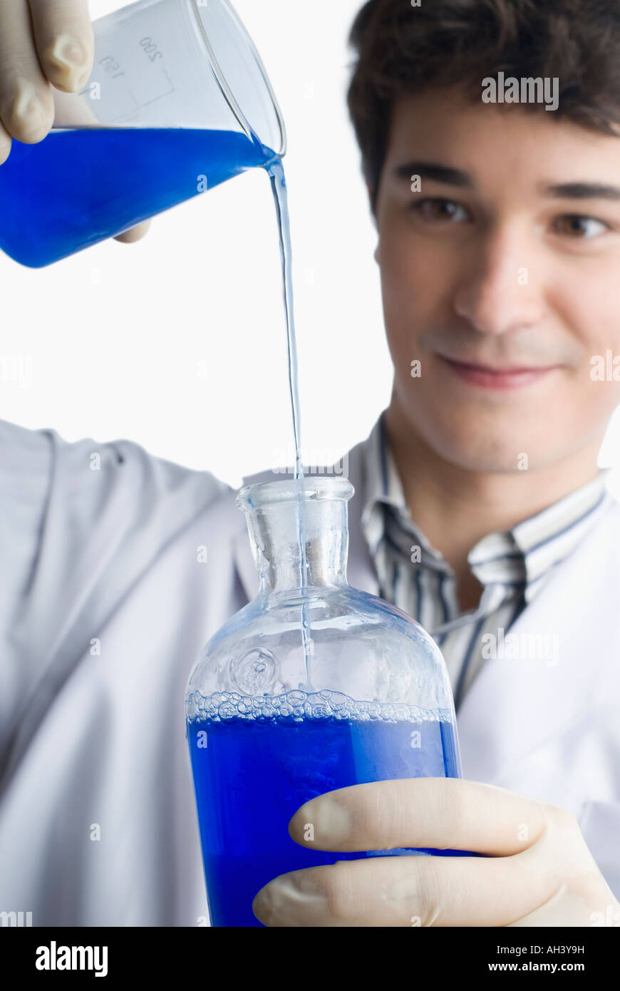 Close-up of a scientist pouring liquid into a flask Stock Photo - Alamy