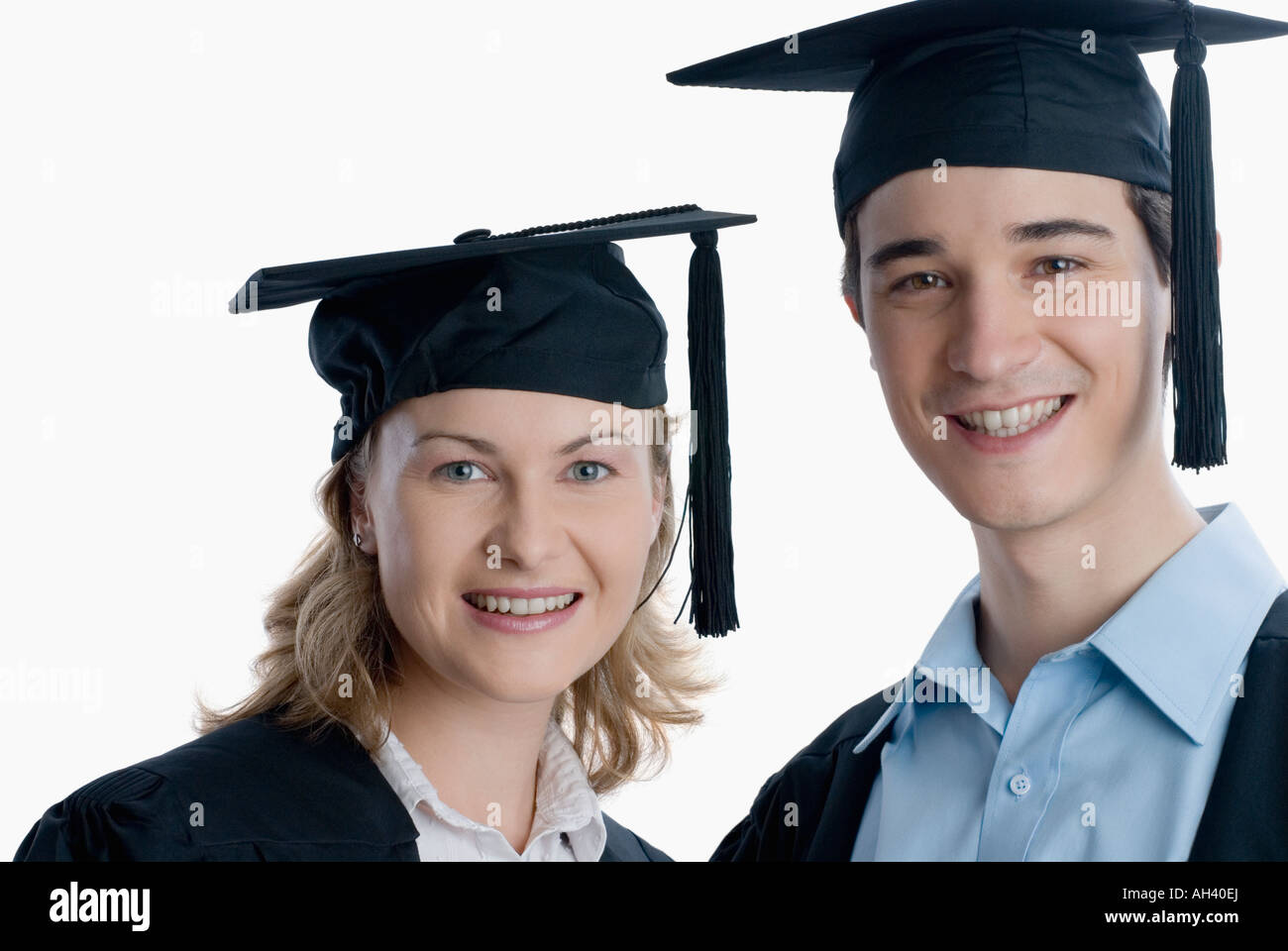 Portrait of a young couple in graduation gowns smiling Stock Photo - Alamy