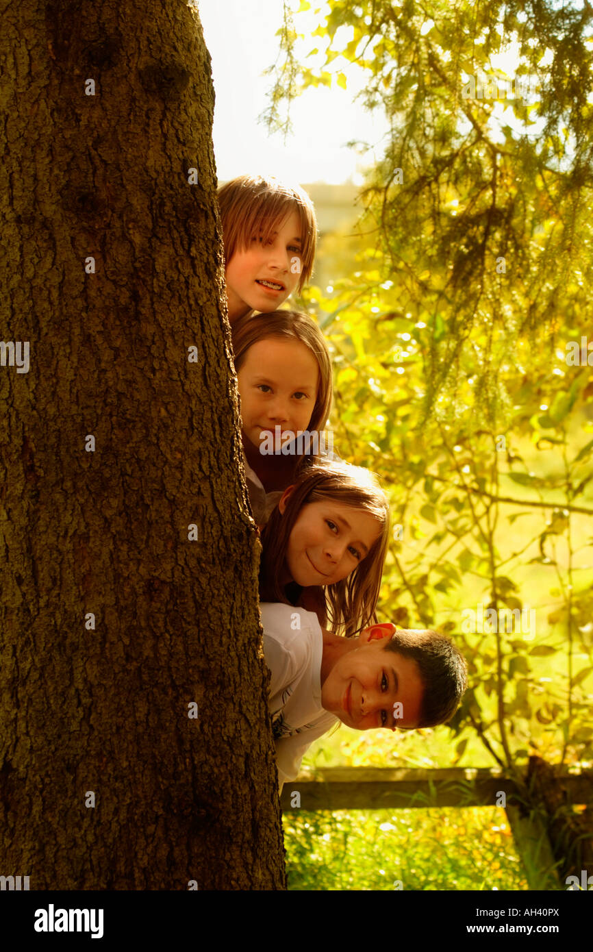 Boy girl hiding behind tree hi-res stock photography and images - Alamy