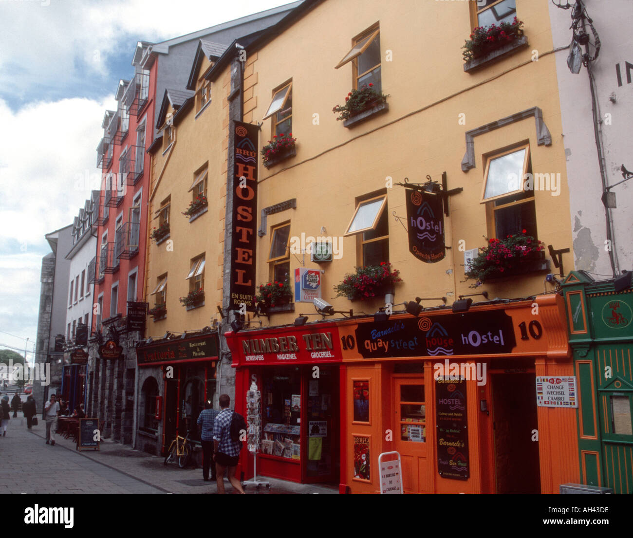 Colorful yellow building with red and orange storefronts on a Galway ...