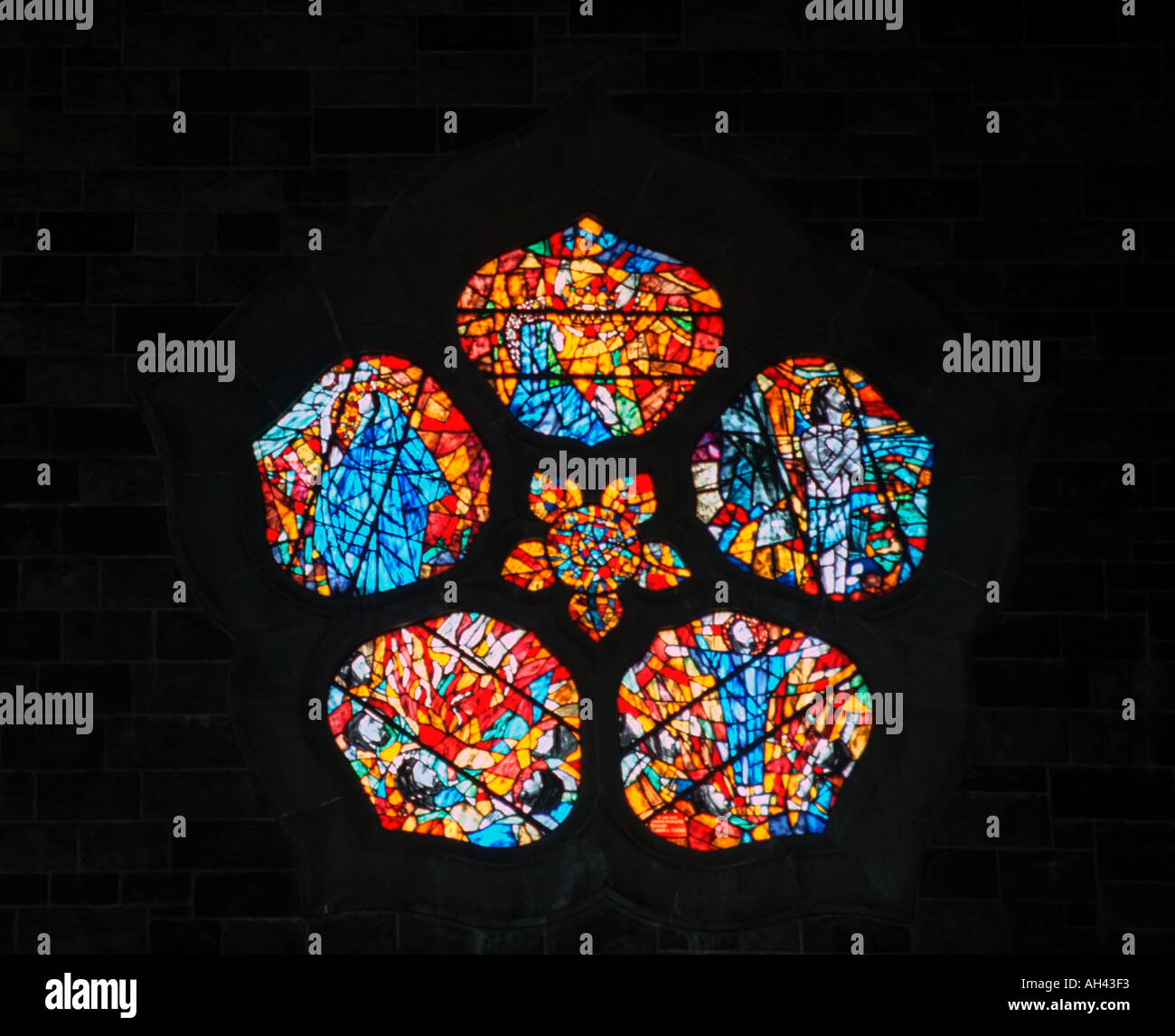 Multicolored rose window against dark wall of interior Galway Cathedral ...