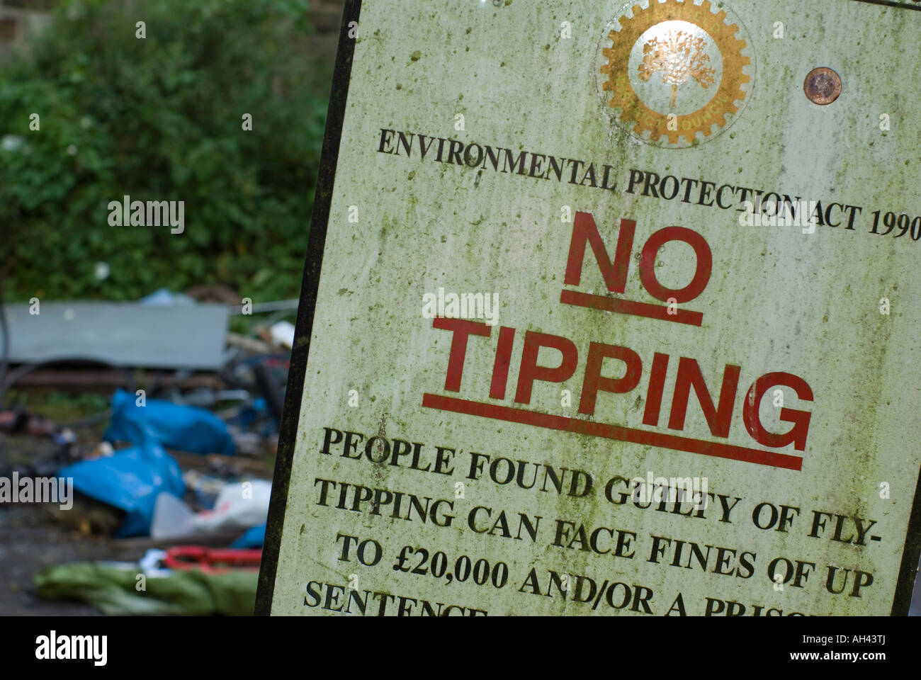 Sign with "No tipping" behind which is rubbish Stock Photo - Alamy