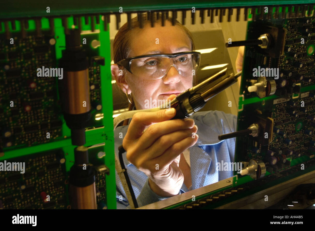Production operator soldering circuit boards at Axiom Manufacturing ...