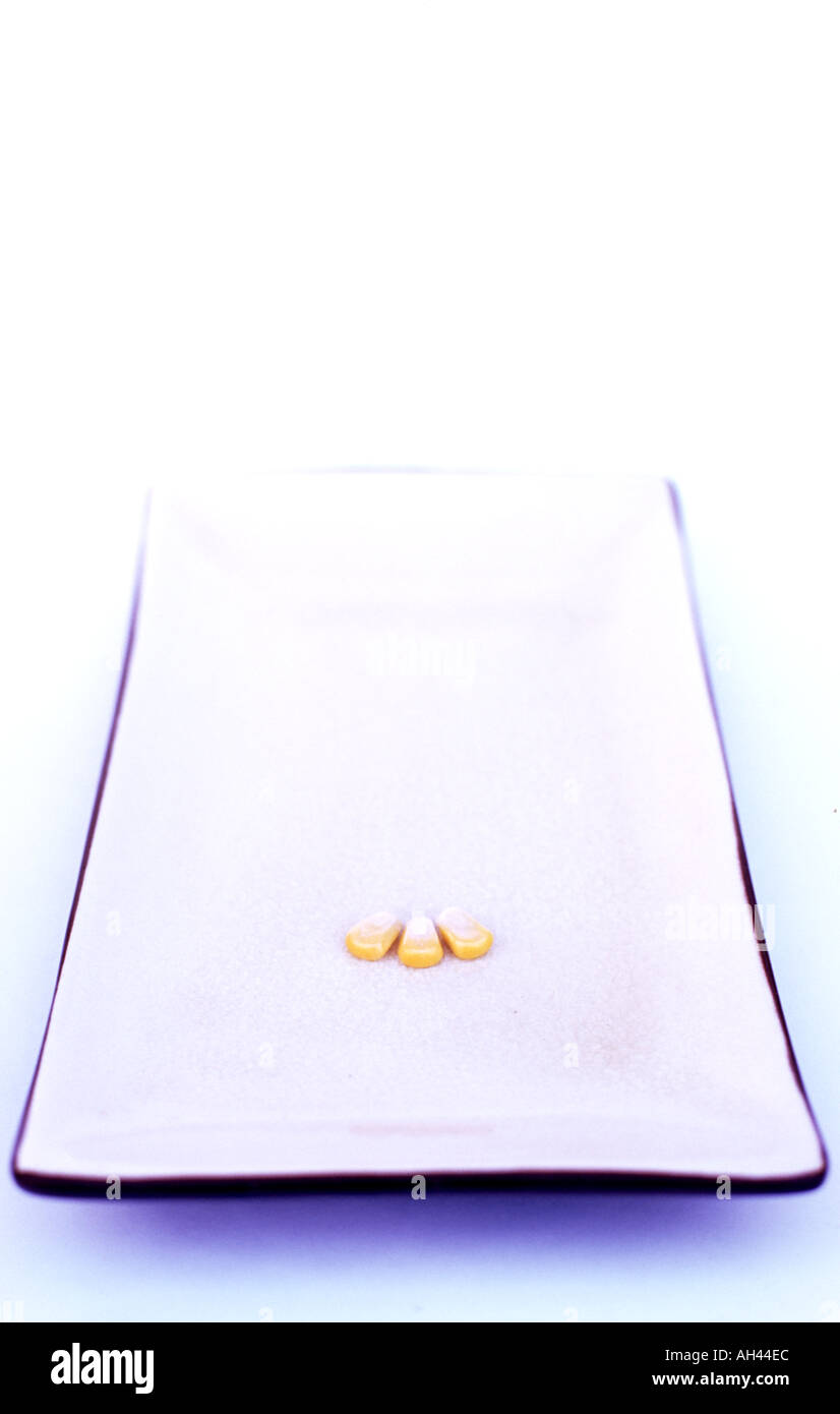 Three corn granules laid out in a fan shape on a lacquered rectangular ...