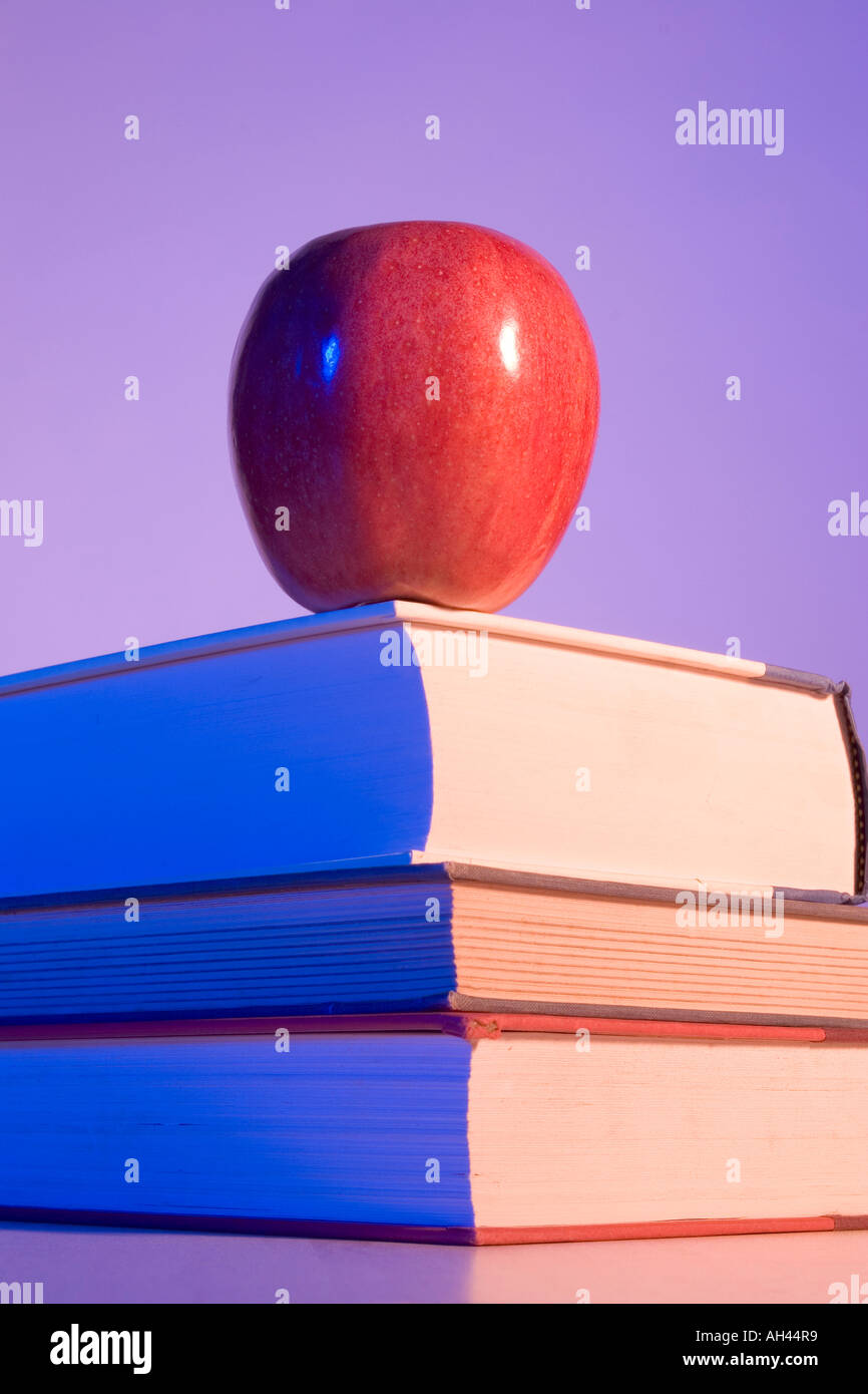 Apple on stack of books Stock Photo - Alamy