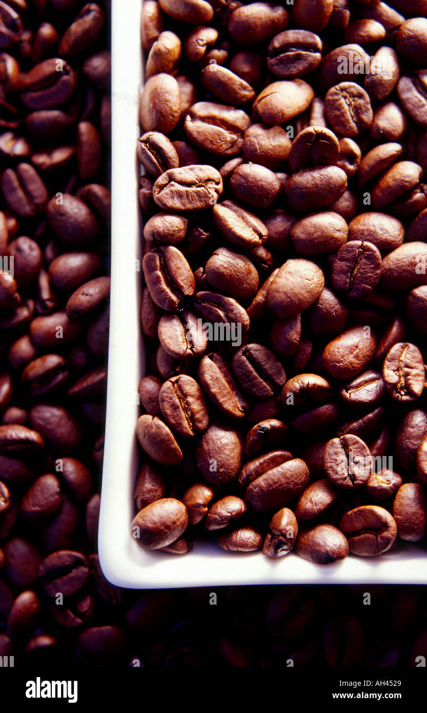 Shallow square white plate filled with roasted coffee beans on top of a ...