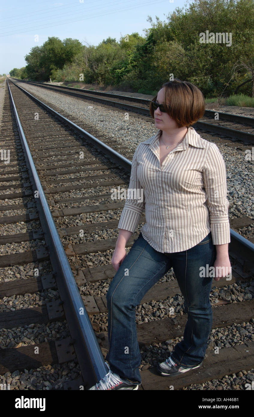 Girl dancing on train tracks Stock Photo - Alamy