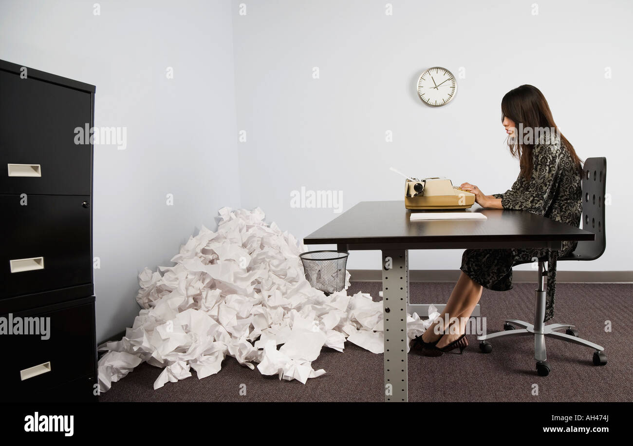 Businesswoman in office with crushed pile of paper on floor Stock Photo ...