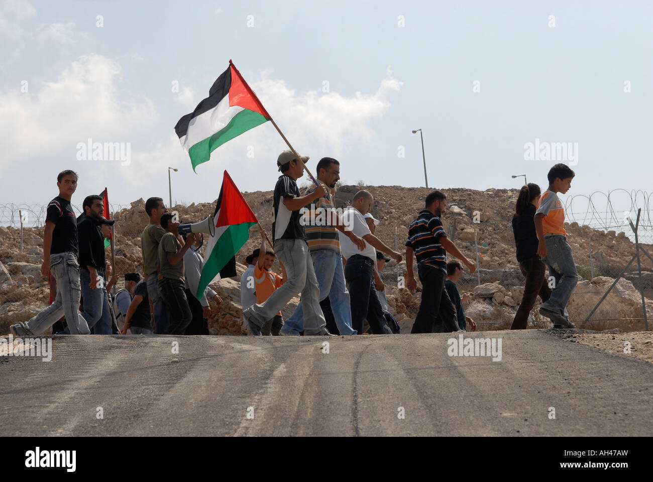 Palestinians walk with Palestinian flags during a protest in the West ...