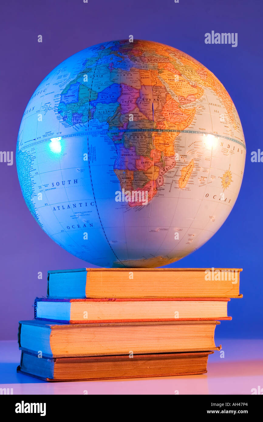Earth globe on stack of books Stock Photo - Alamy