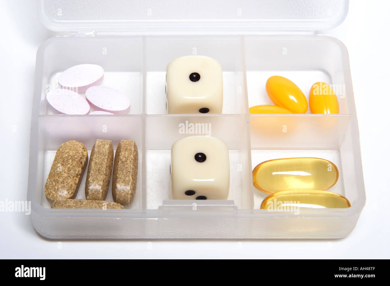 Pillbox with vitamins and dice Stock Photo - Alamy