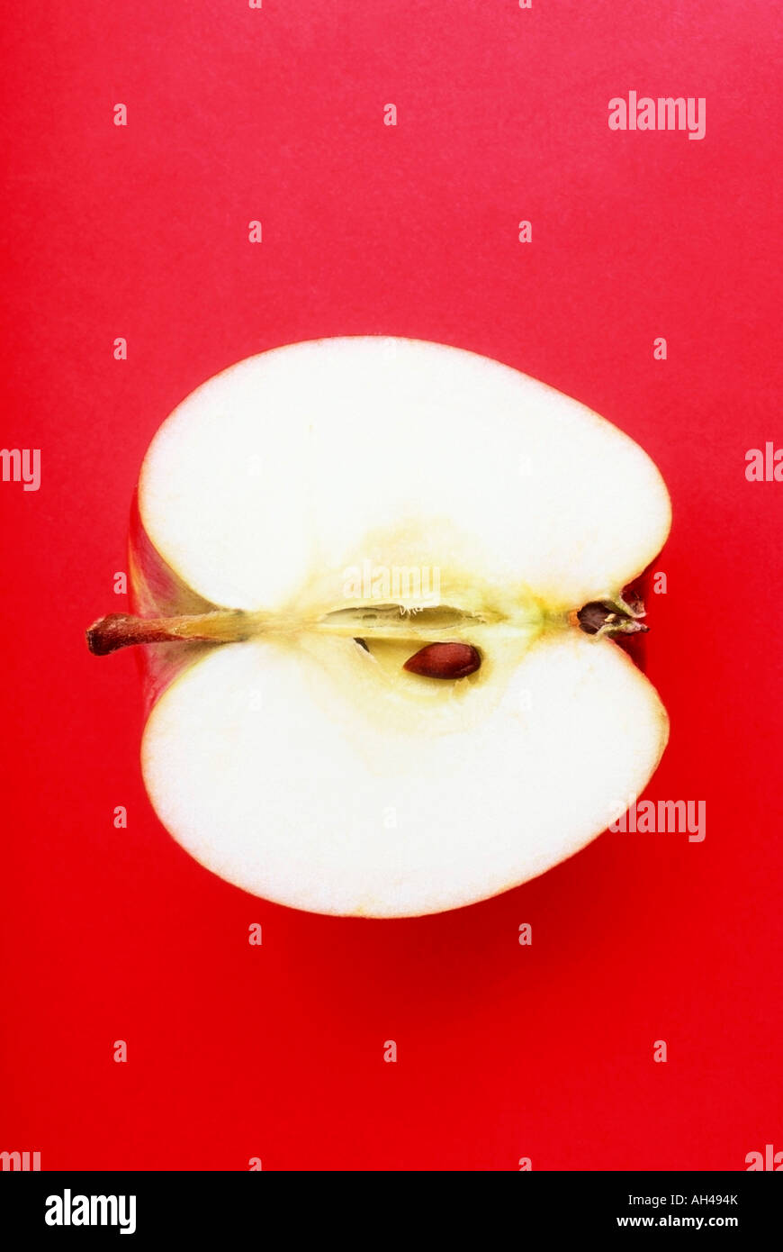 Half an apple on red background Stock Photo - Alamy