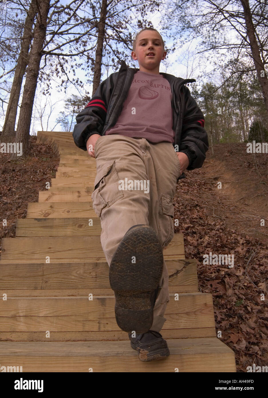 Energetic young boy, 10-12 years old, high-stepping down outdoor stairs ...