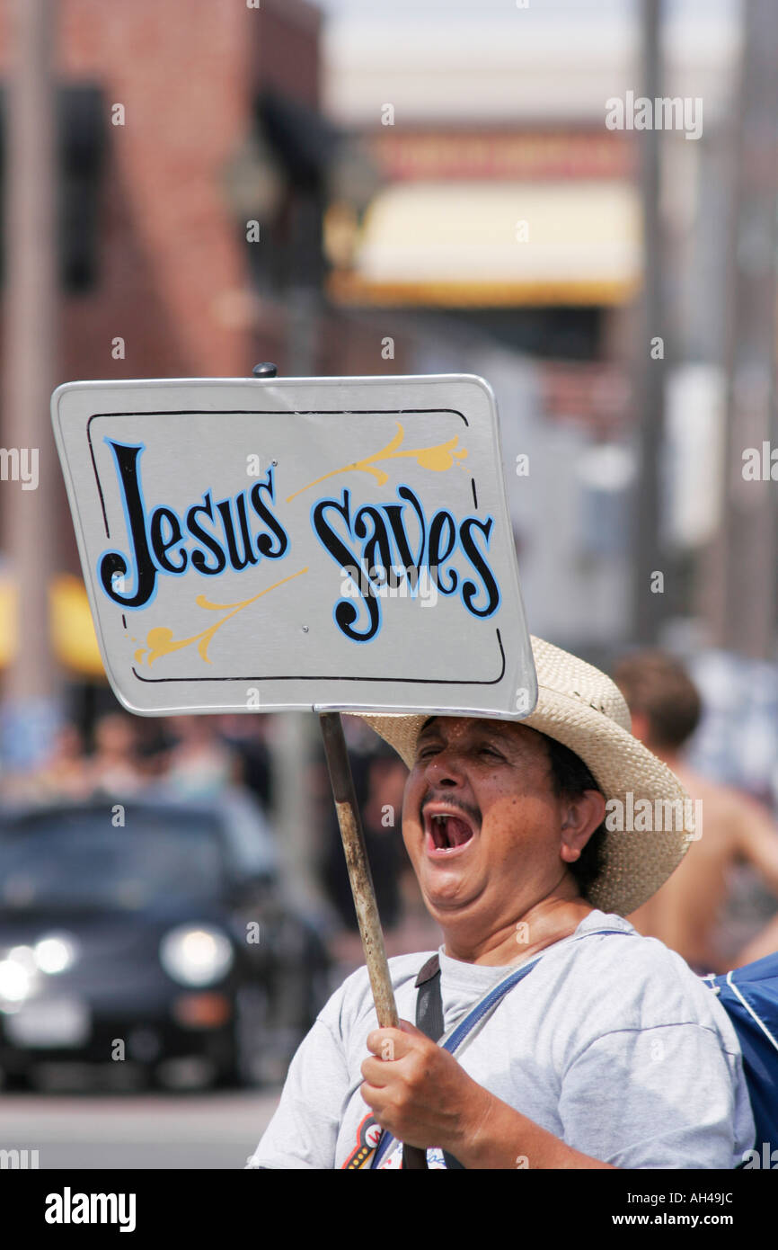 Hispanic man in the street holding a sign and preaching about Jesus ...