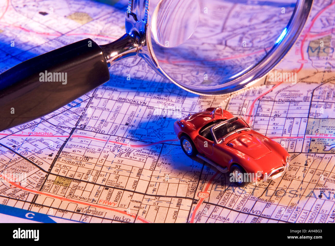 Magnifying glass, map and toy car Stock Photo - Alamy