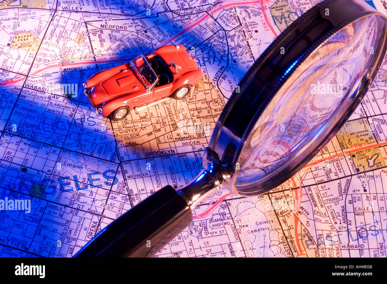 Magnifying glass, map and toy car Stock Photo - Alamy