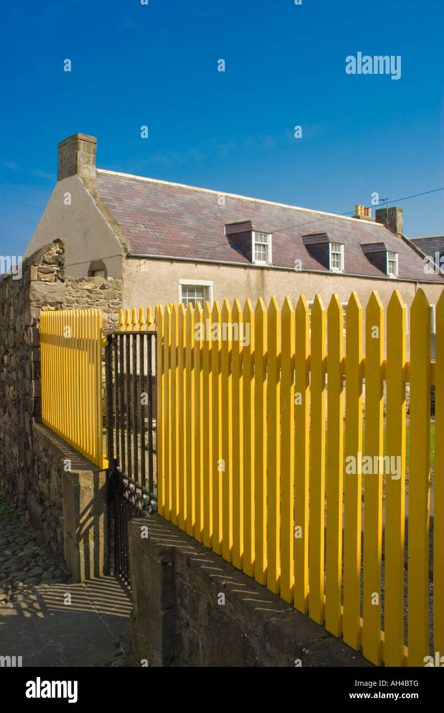 Bright Yellow Garden Fence Against a Bold Blue Sky Stock Photo - Alamy