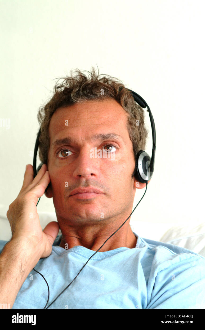 A man listening to his headset / earphones / headphones Stock Photo - Alamy
