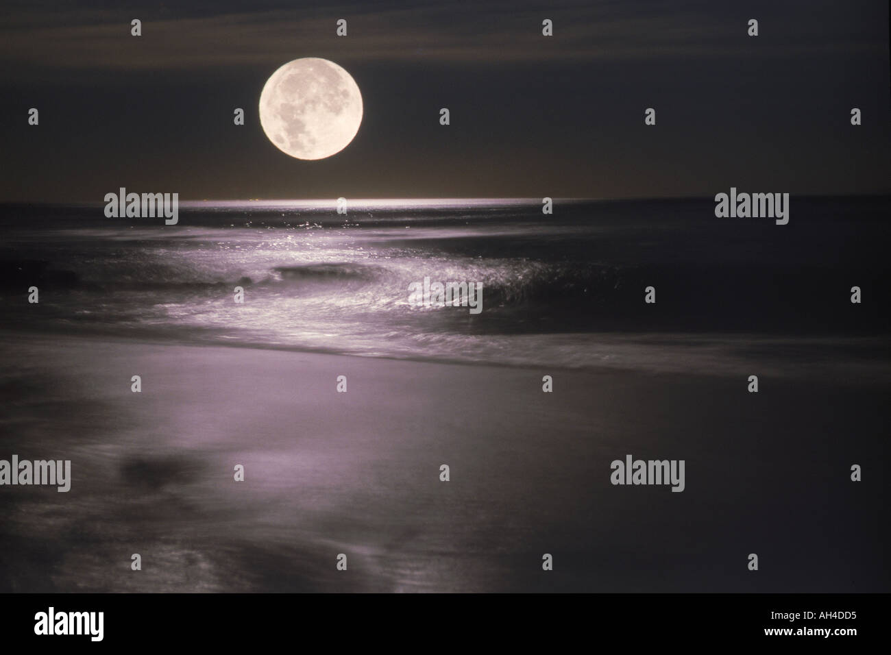 Full moon reflecting across ocean at night Stock Photo - Alamy