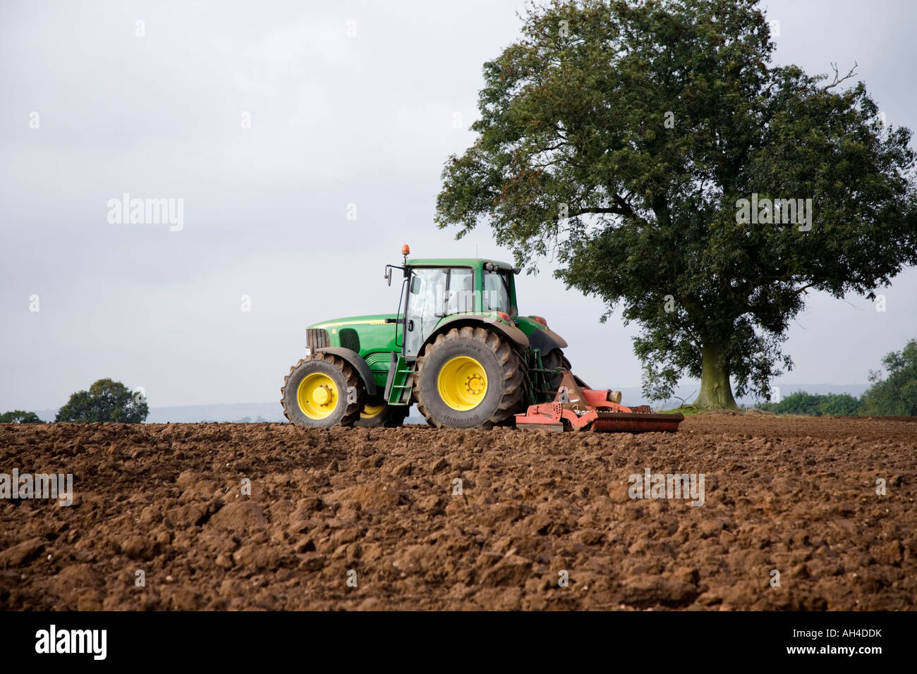 Tractor disc harrowing a field Stock Photo - Alamy