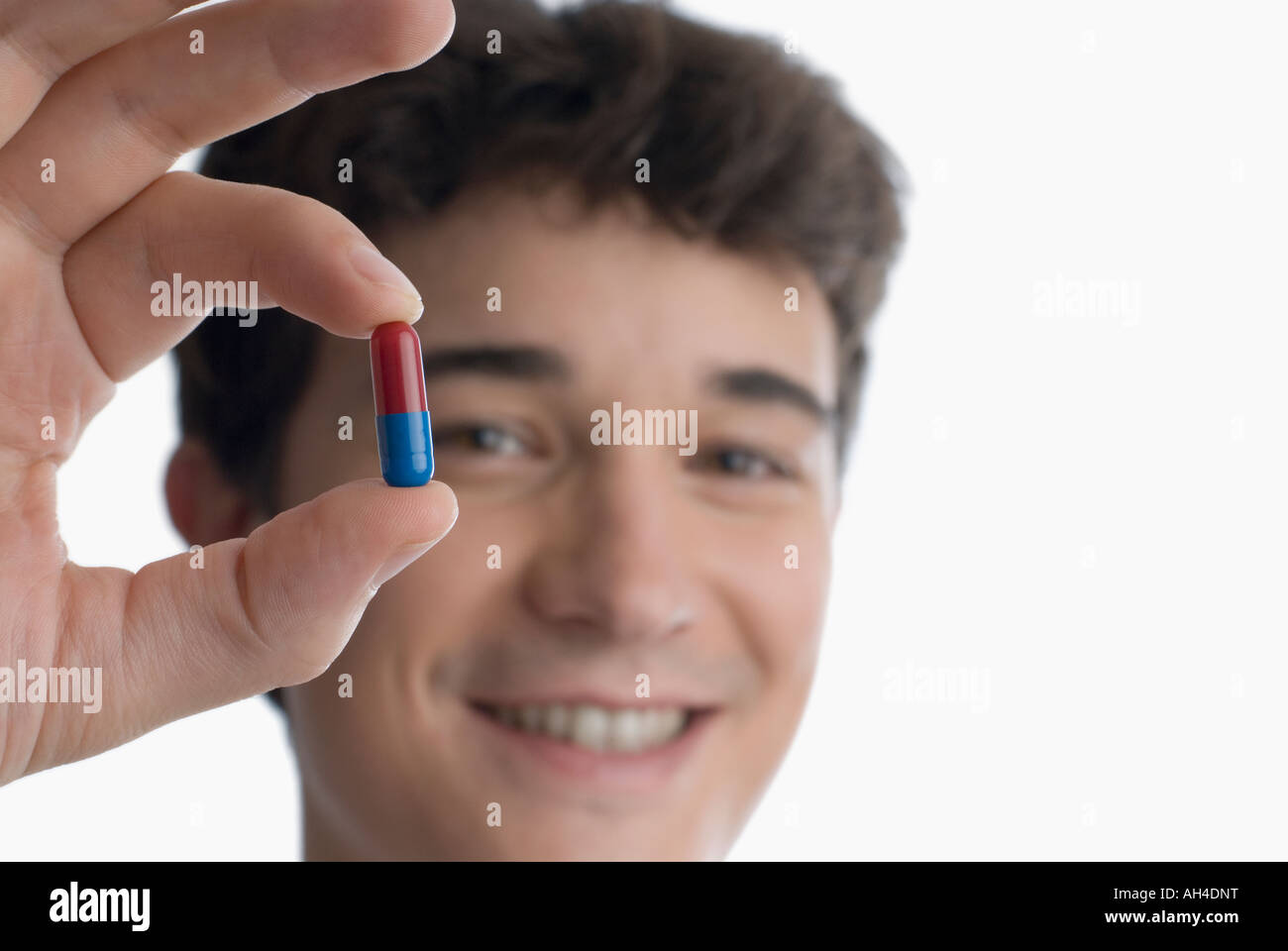 Portrait of a young man holding a capsule and smiling Stock Photo - Alamy