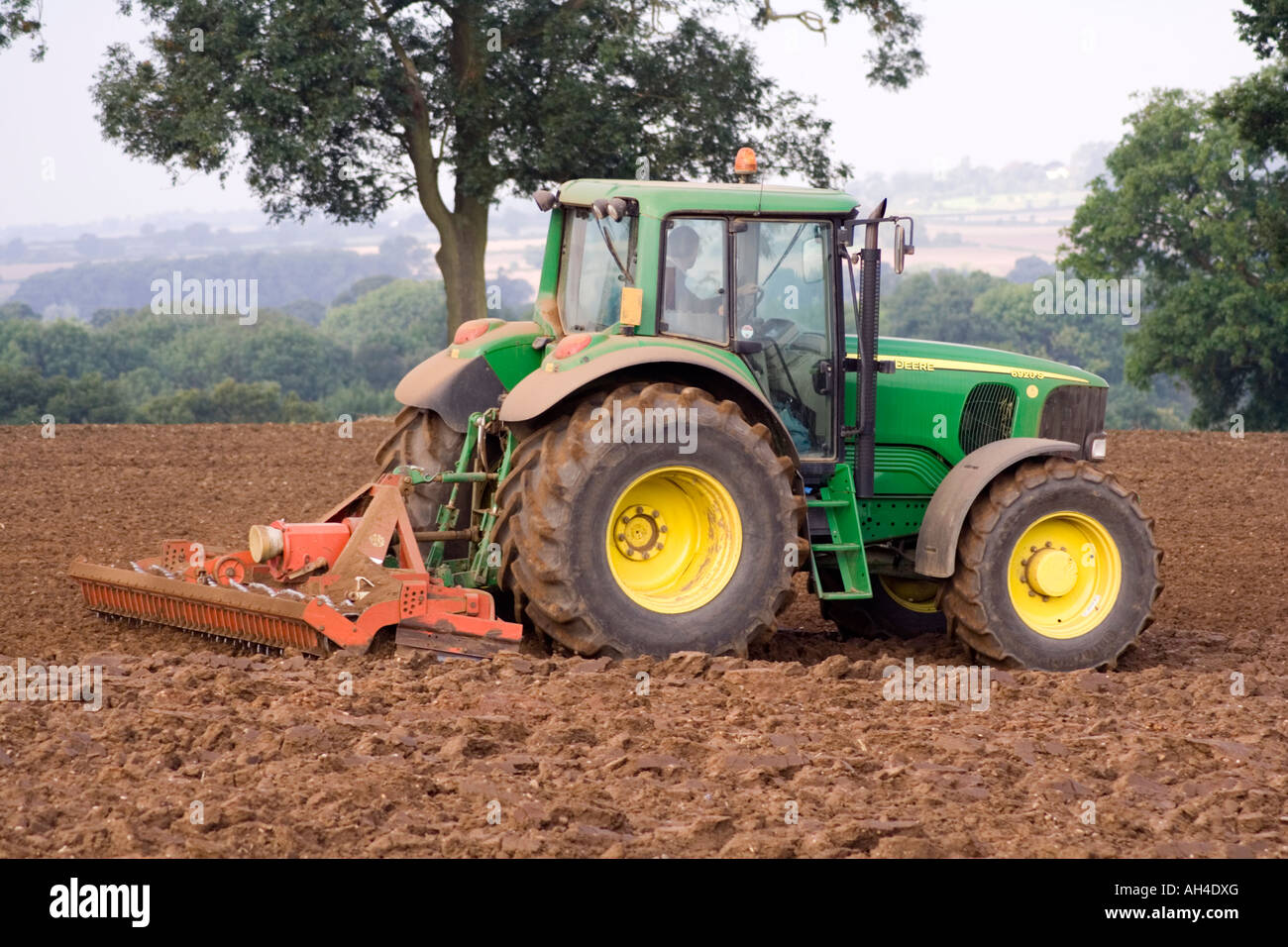 Tractor disc harrowing a field Stock Photo - Alamy