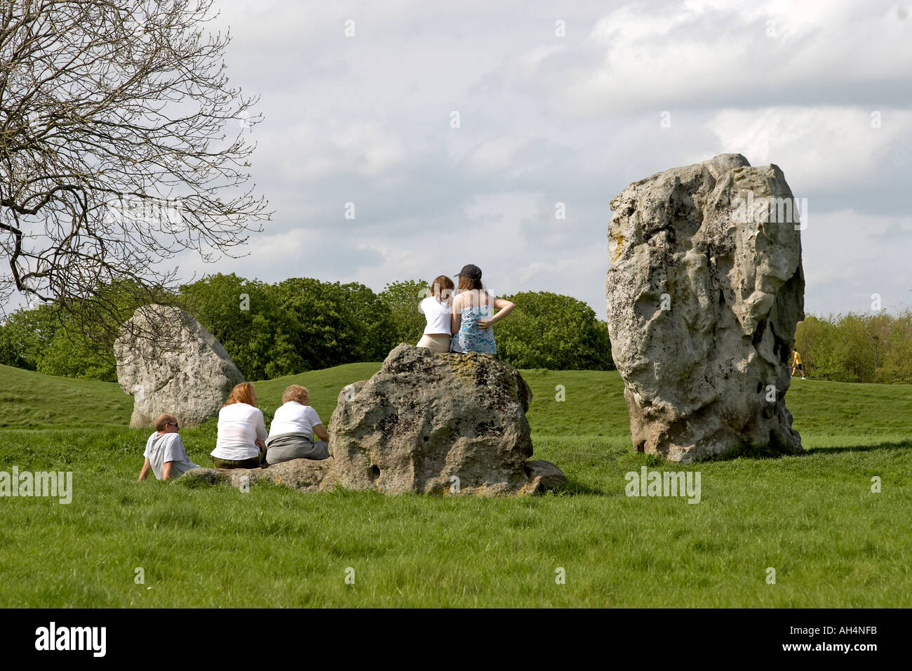 Family sitting on standing stones at at Avebury Ring Stone Circle ...