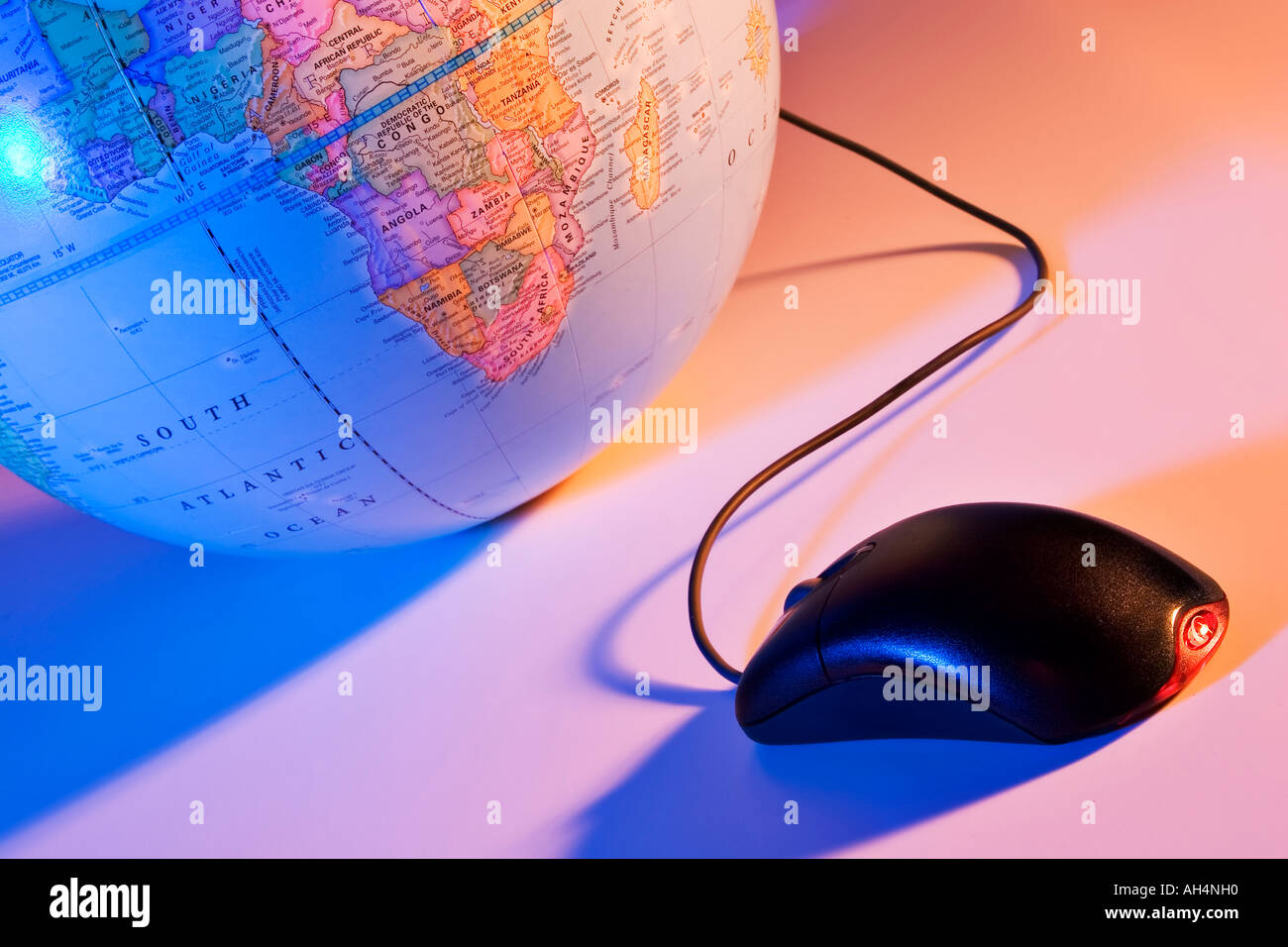 Computer mouse connected to an earth globe Stock Photo - Alamy