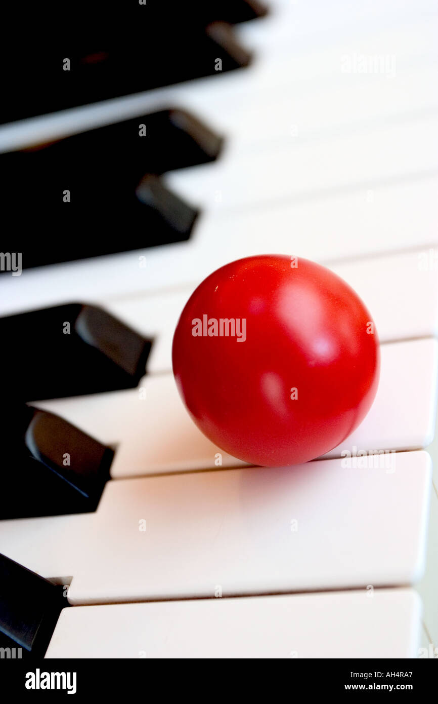 Piano keyboard close up with alone solo tomato Stock Photo - Alamy