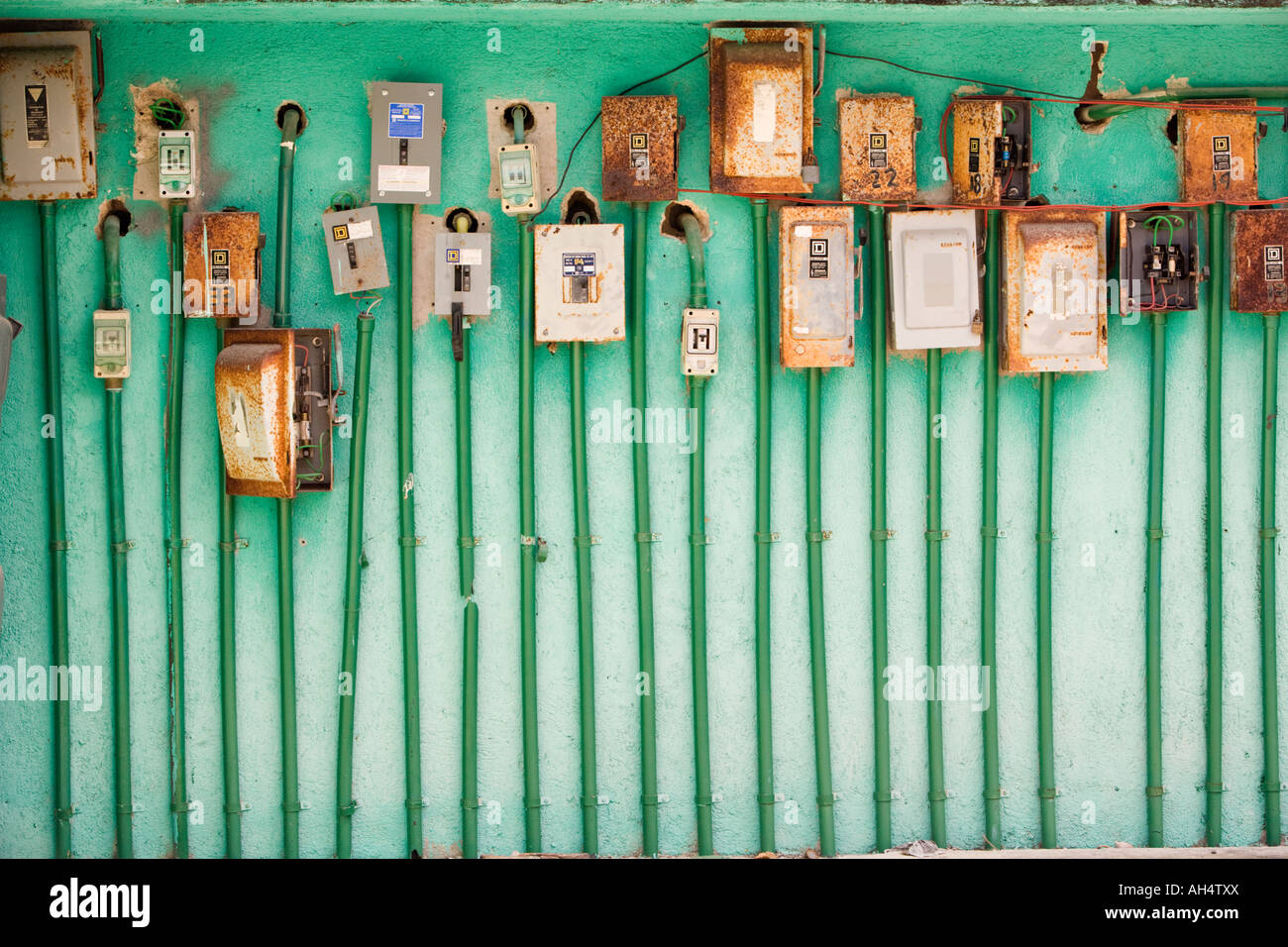 Many rusted electric panels on a green wall Stock Photo - Alamy