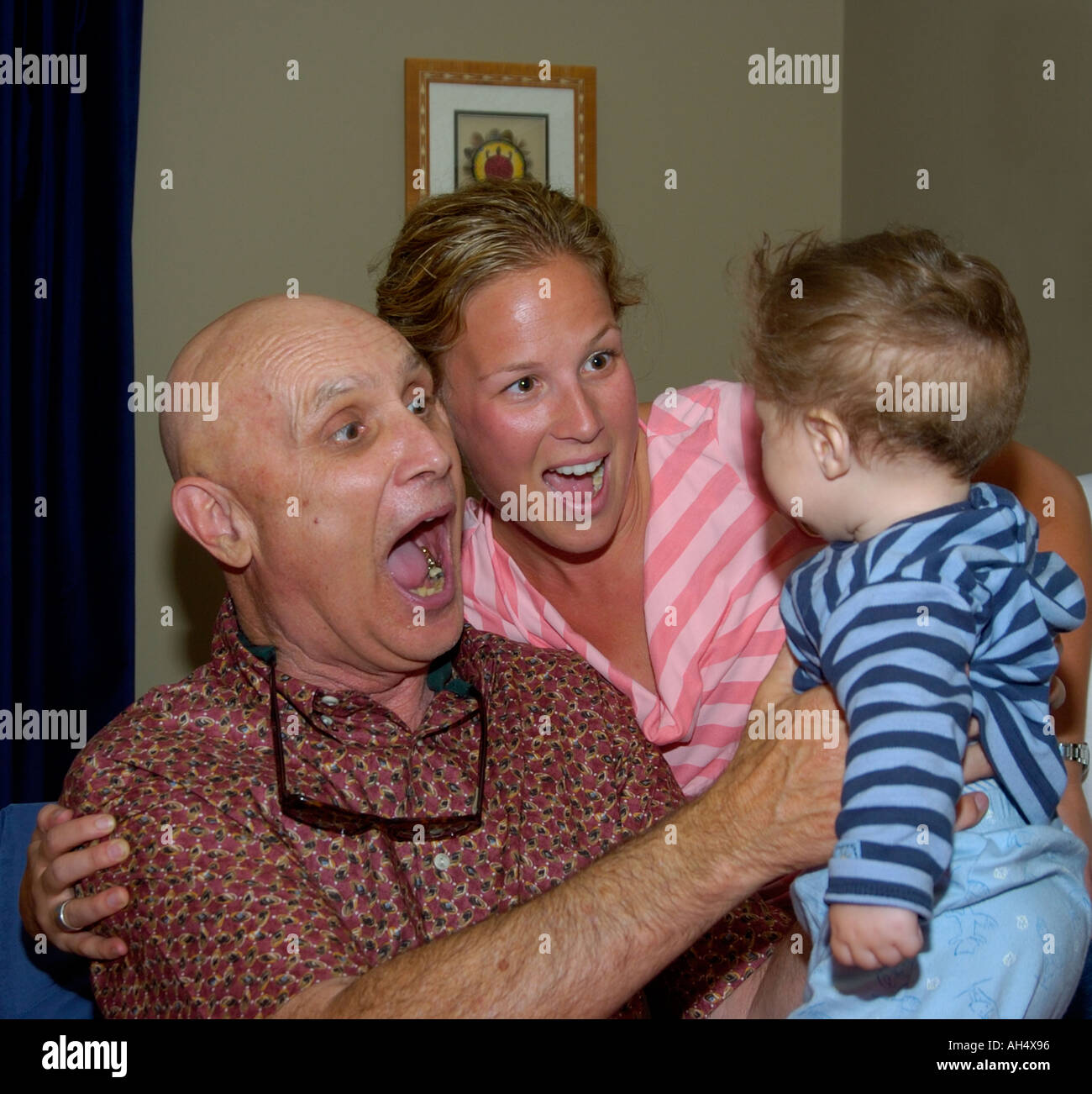 Father and daughter making faces to entertain the baby Stock Photo - Alamy
