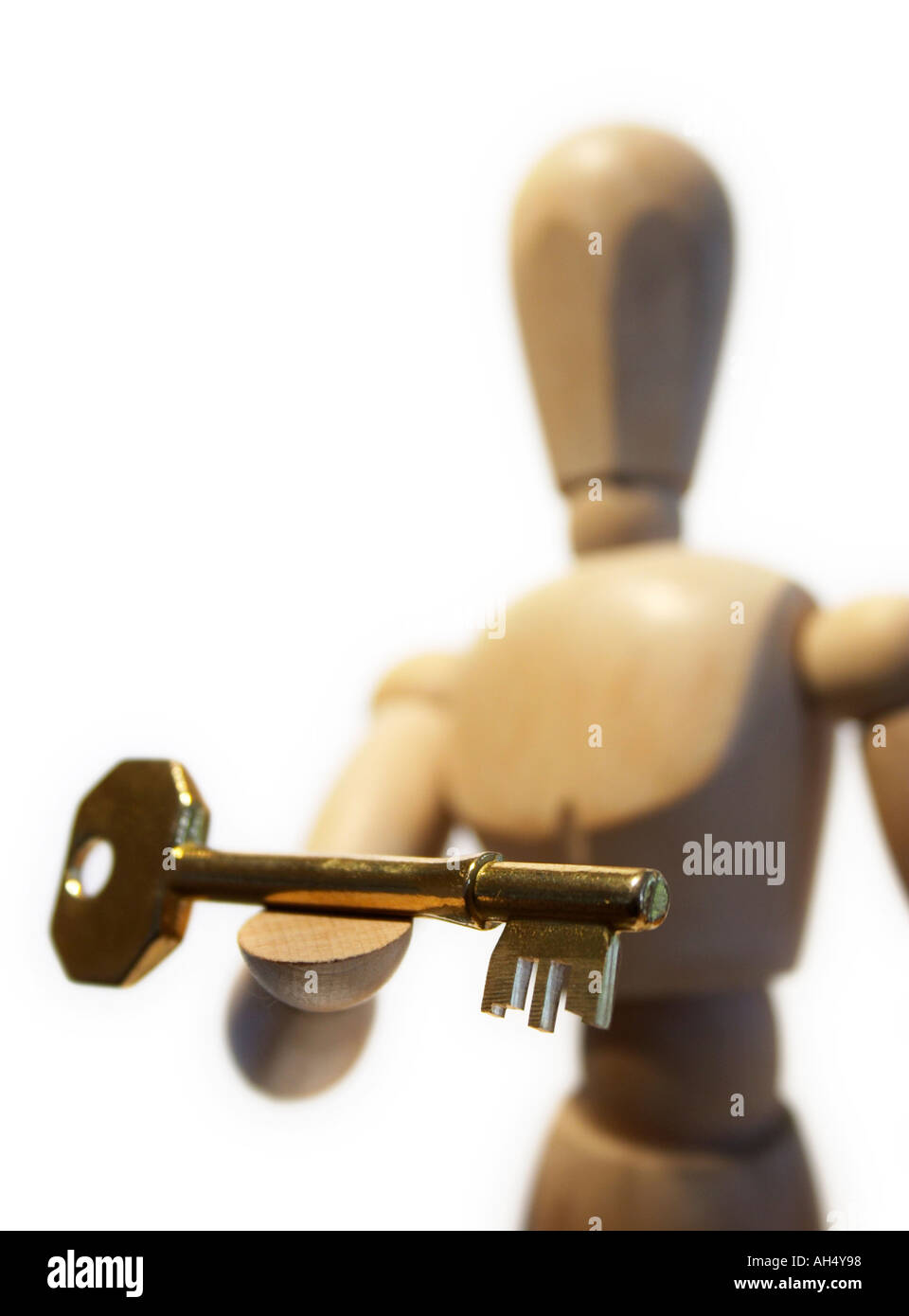 Wooden man offering a key against a white background Stock Photo - Alamy