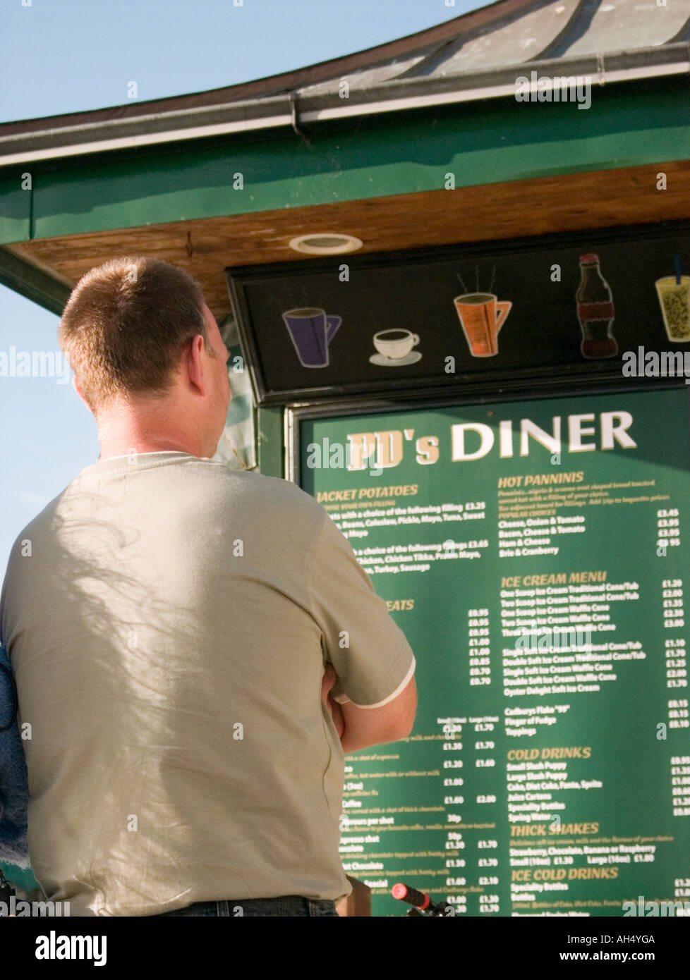 Man looking at menu at PD's Diner, Aberystwyth promenade in the summer ...