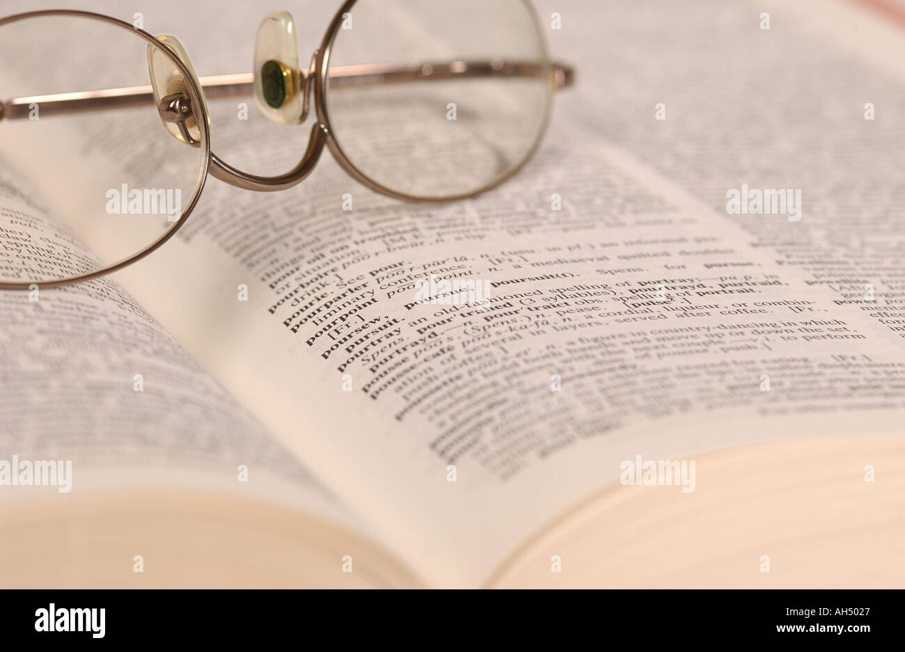 Close up of open Dictionary page pages with glasses specs spectacles ...